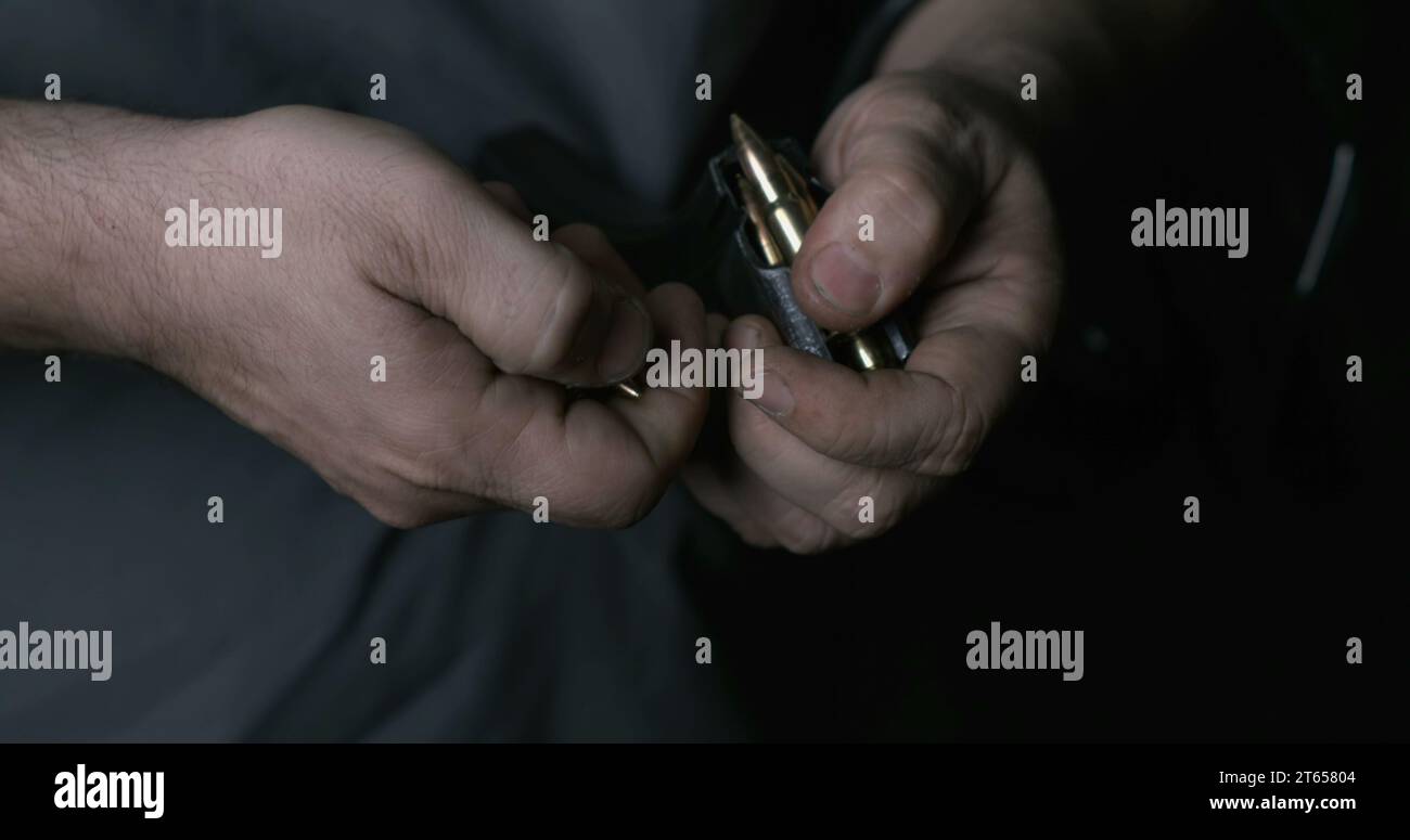 Close-up hand Reloading ammunition. Bullets into clip Stock Photo - Alamy