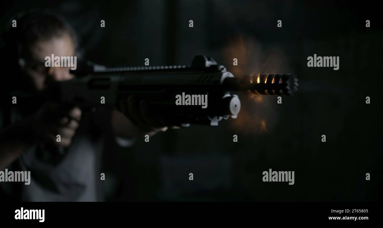 Close-up of man aiming and firing a shotgun in high-speed with smoke ...