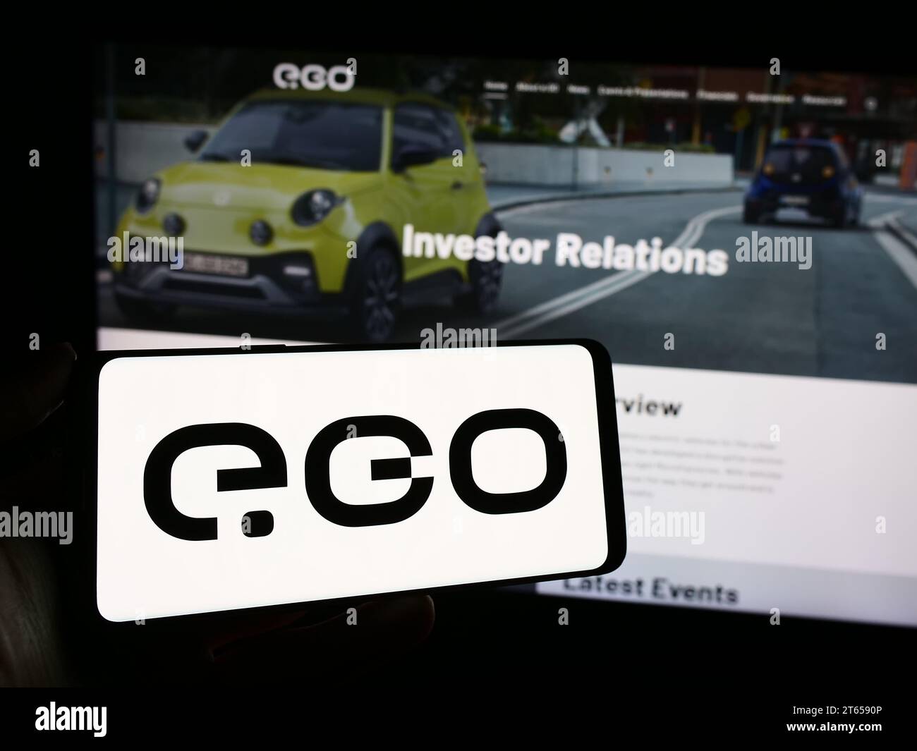 Person holding cellphone with logo of German electric vehicle company ...