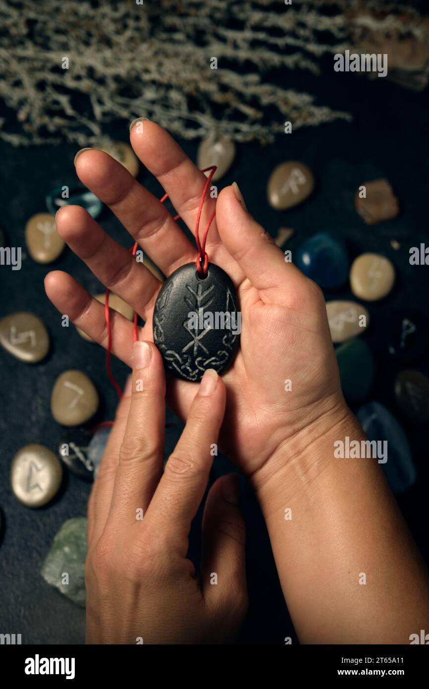 stone runic talisman for good luck in your hand Stock Photo - Alamy