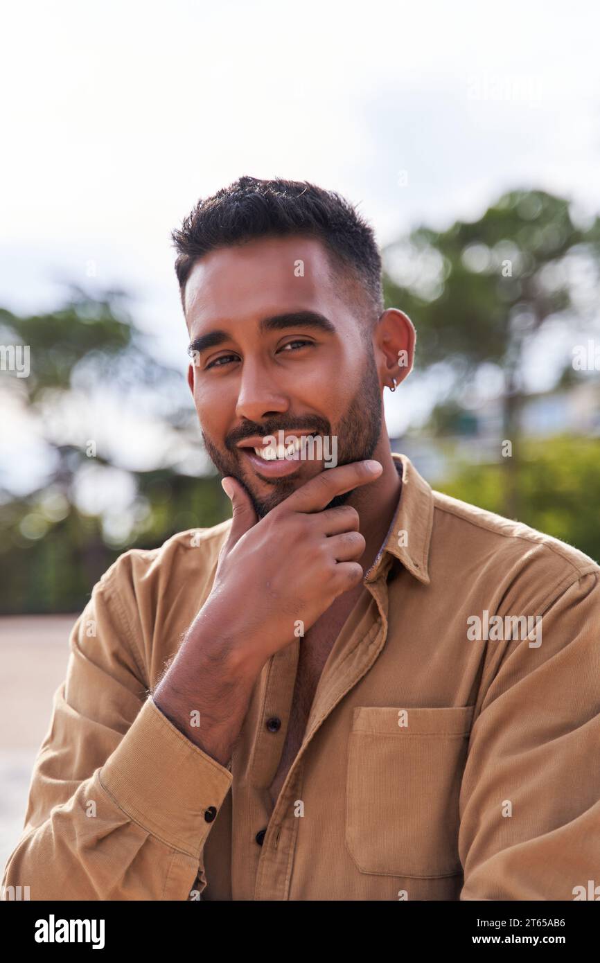 portrait of a handsome latin young man posing with his hands on his ...