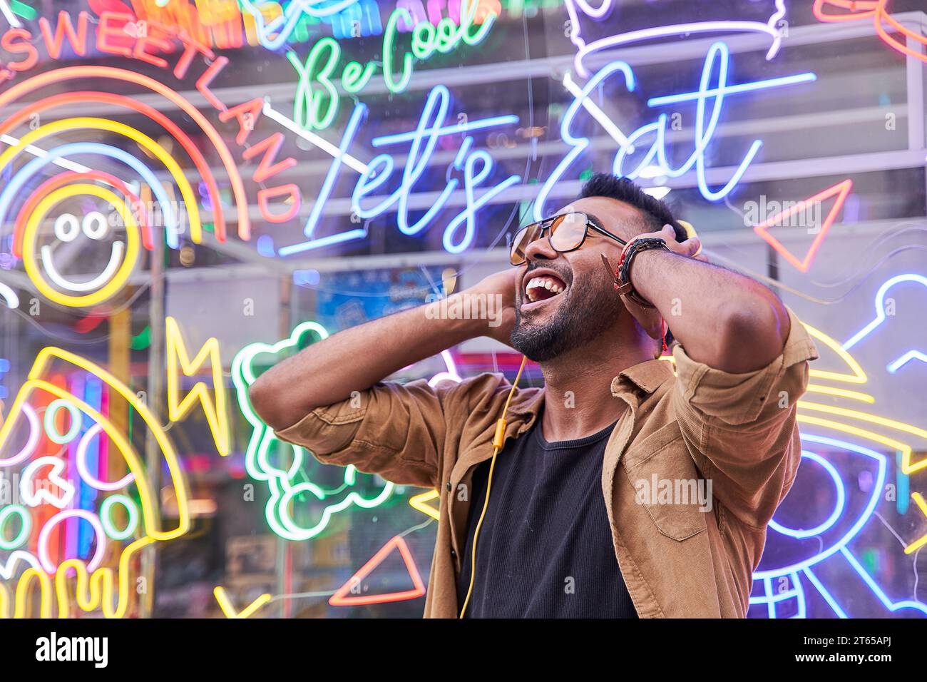 Delighted carefree male with sunglasses dances in rhythm of melody ...