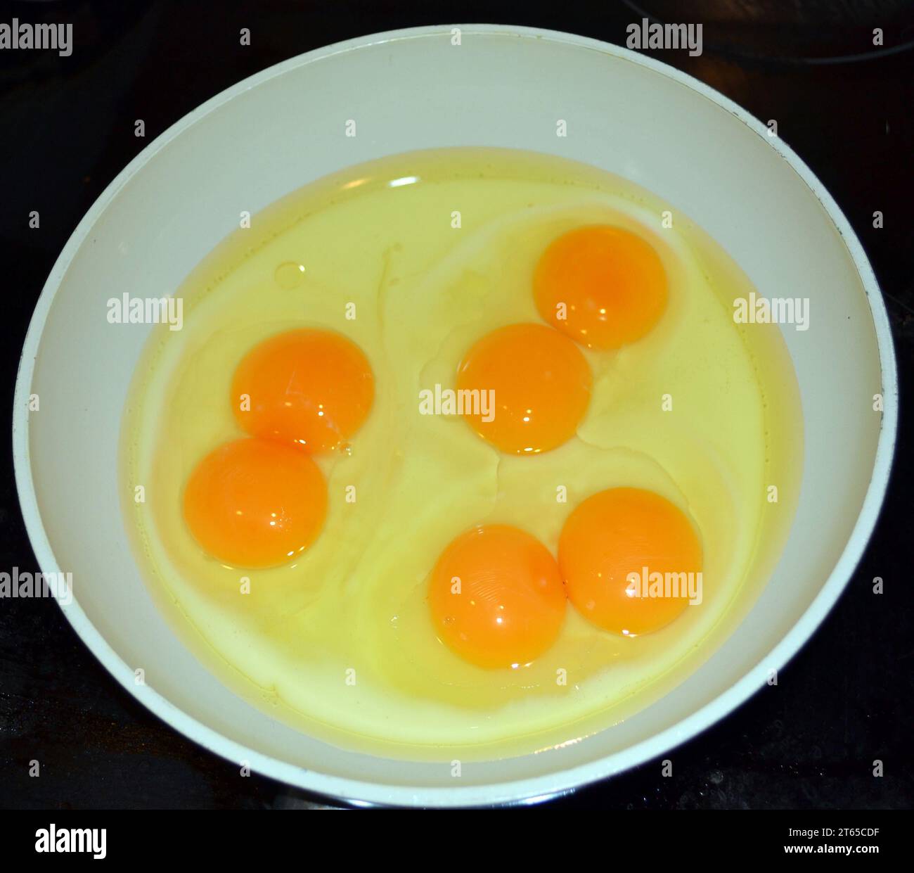 Three eggs with double yolk in a pan Stock Photo - Alamy
