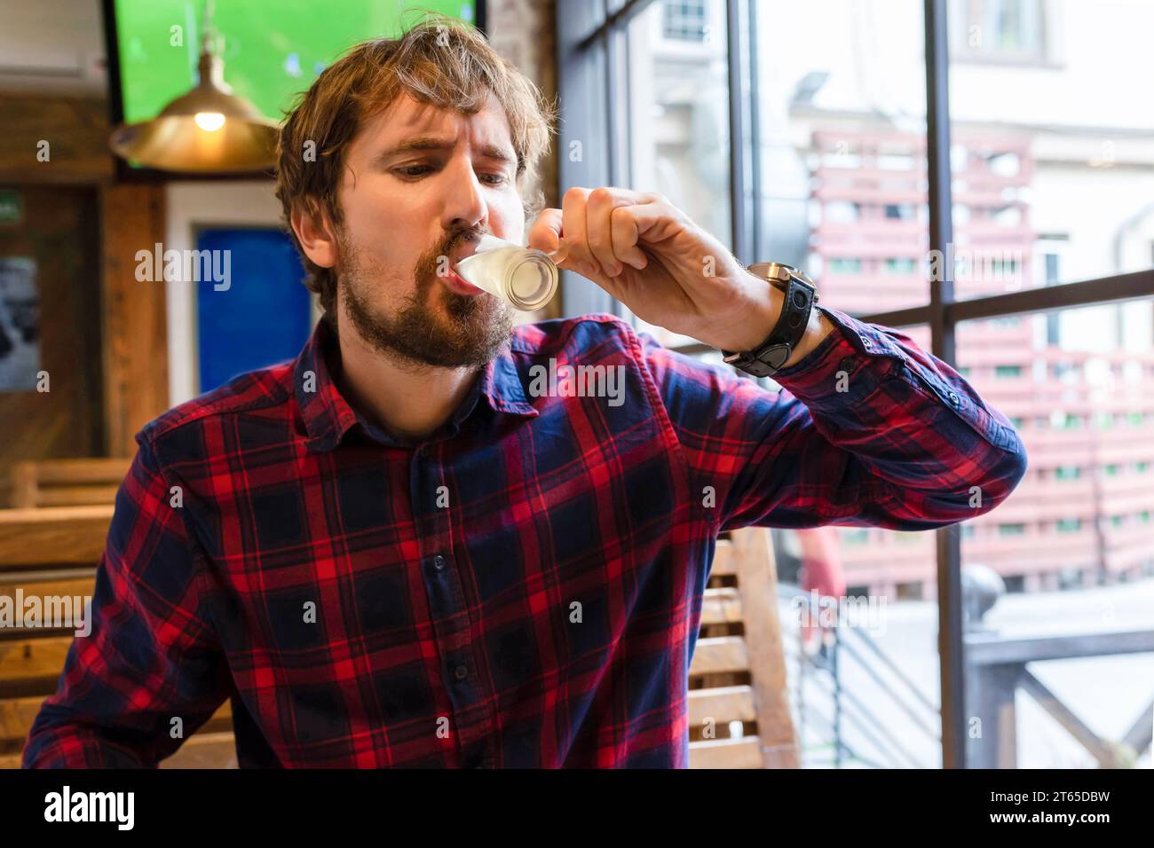 Lonely man drinking strong alcohol in a bar. A person in depression, in ...