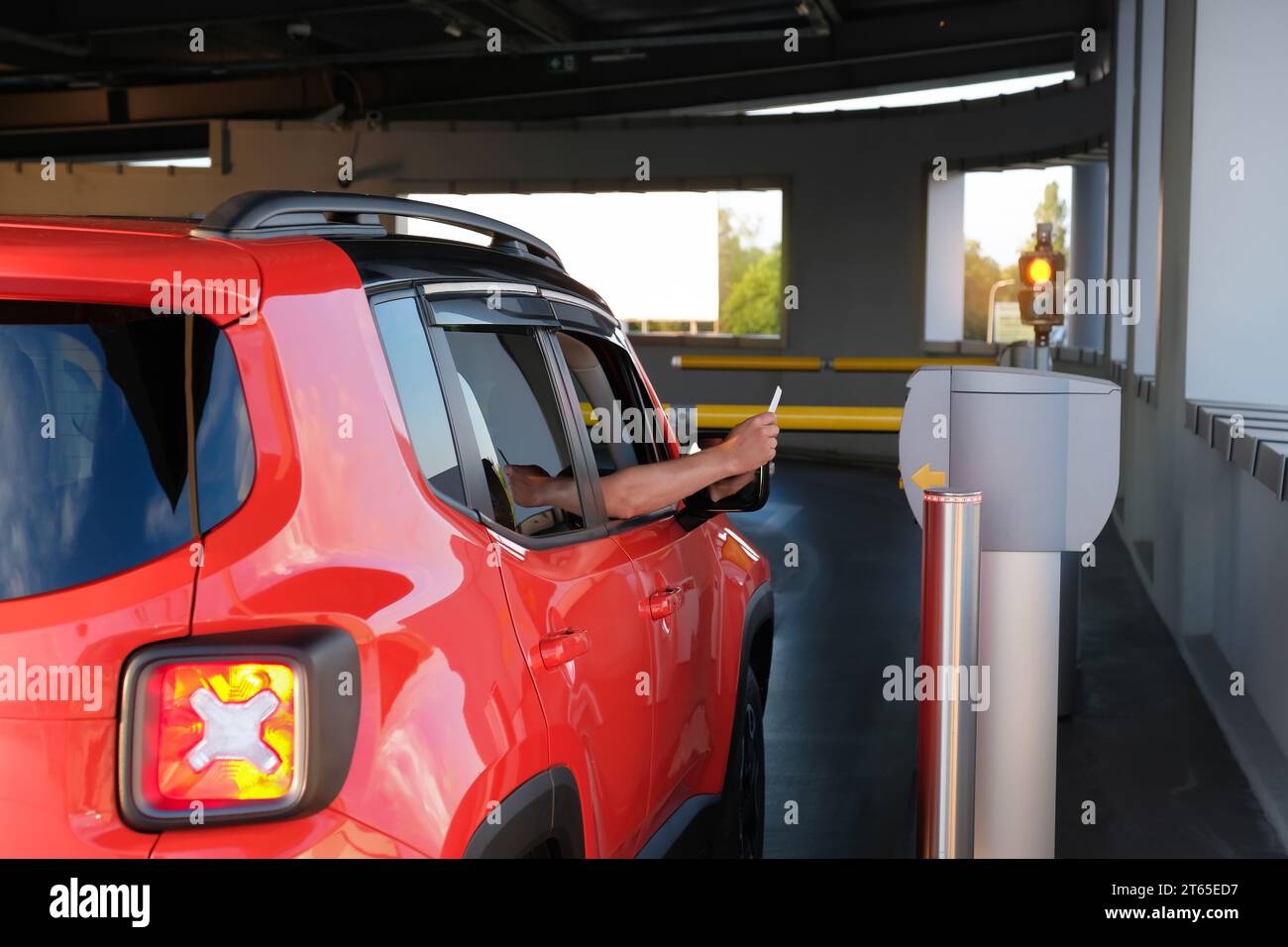 A man takes a parking ticket at the entrance to a paid underground ...