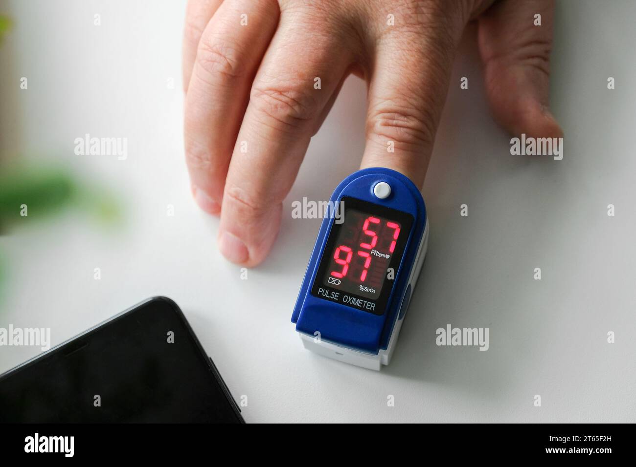 A pulse oximeter on a human finger measures oxygen in the blood. Top ...