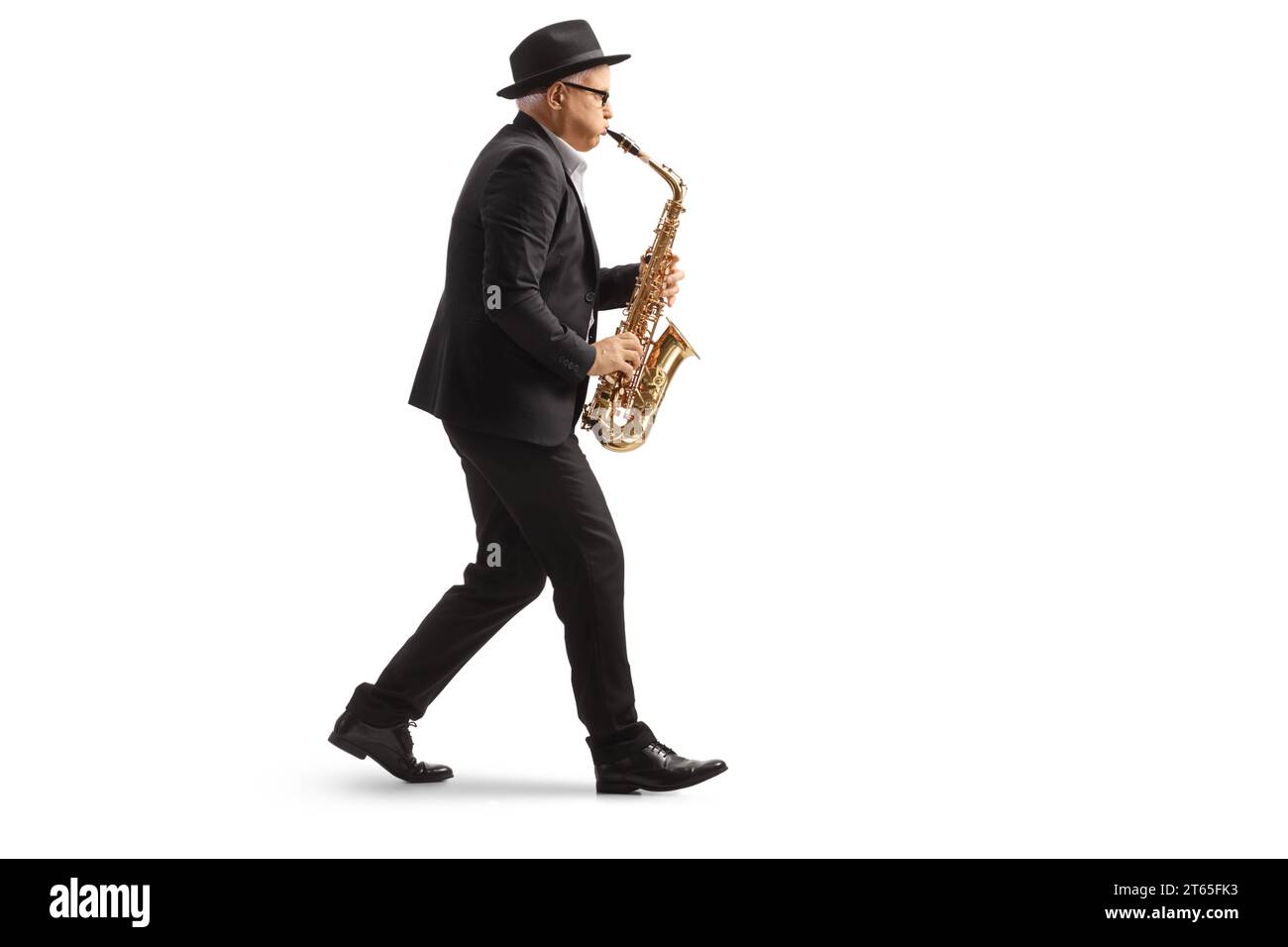 Full length profile shot of a man walkign and playing a sax isolated on ...