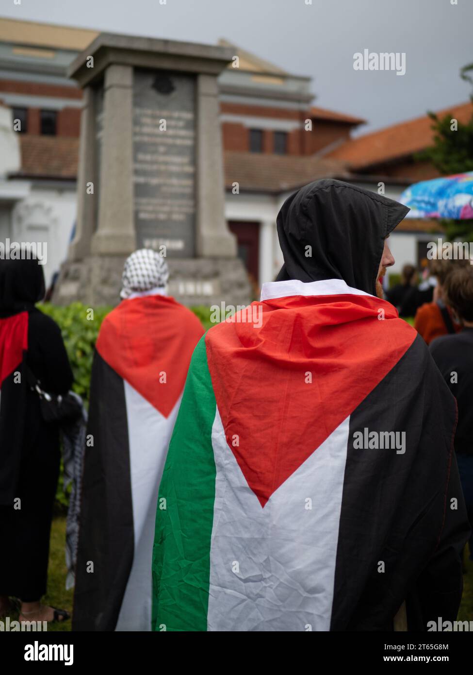 Protesters seen draped with Palestinian flags during the rally. Merri ...