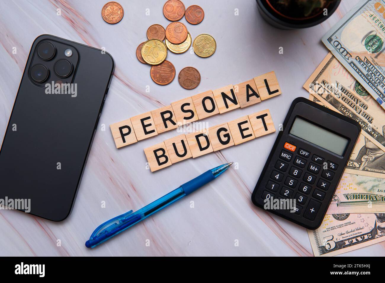 Flat lay photo showing the words personal budget next to money, a ...