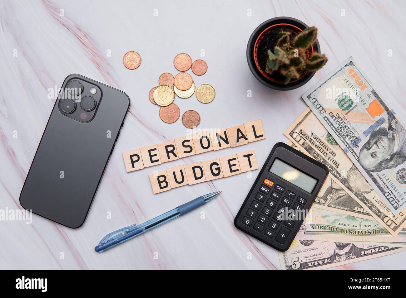 Flat lay photo showing the words personal budget next to money, a ...