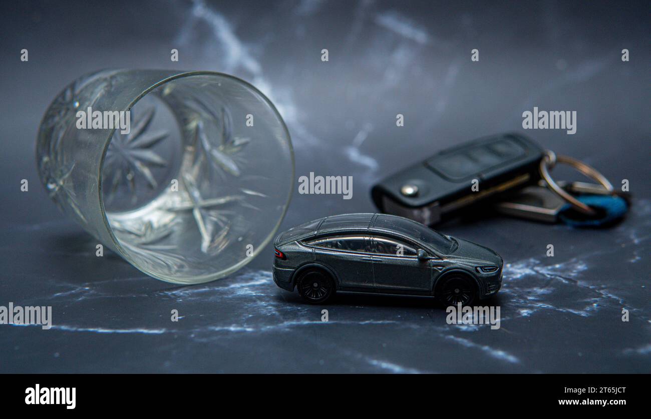 concept showing drunk driving. A toy car next to alcohol glasses ...