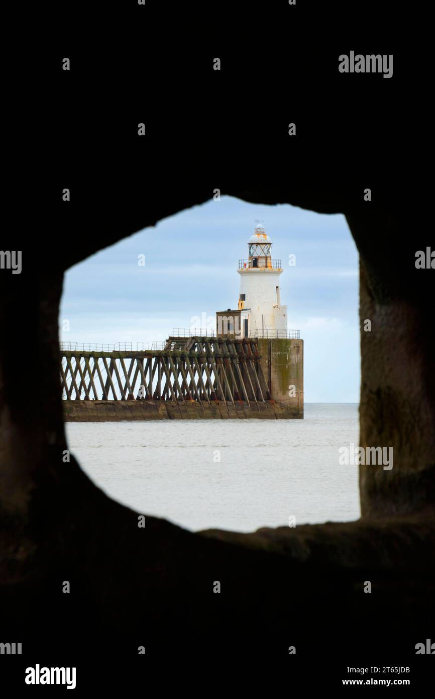 Lighthouse on the East Pier Of Blyth Harbour framed by the structure of ...