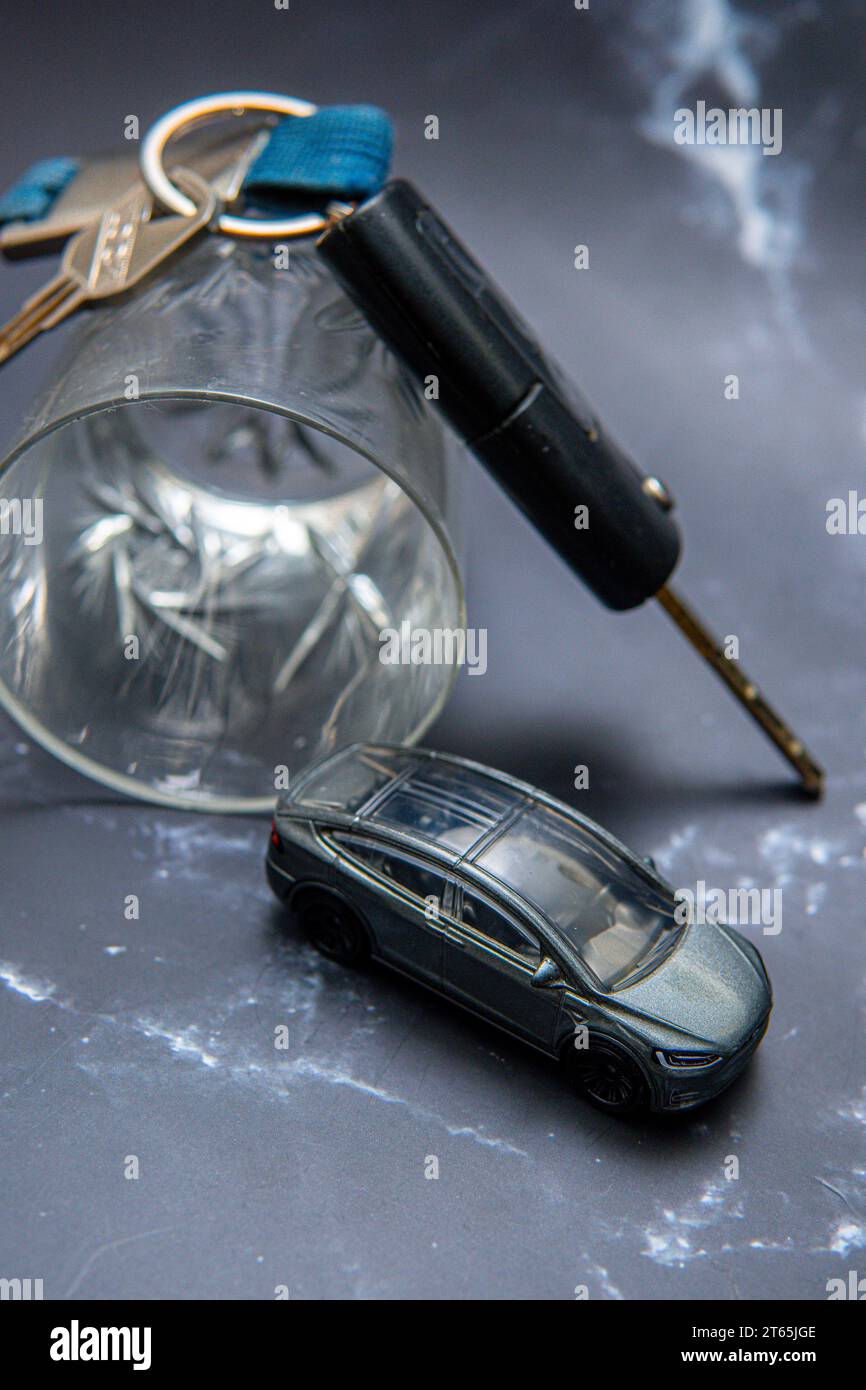 concept showing drunk driving. A toy car next to alcohol glasses ...