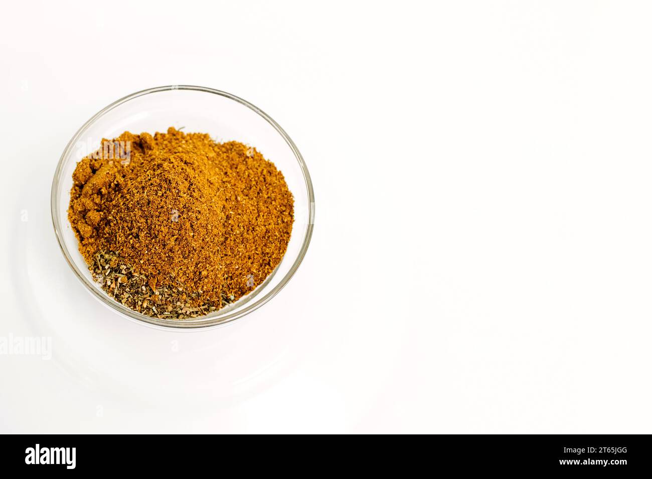 Homemade spice mixture in a glass plate on a white background. Close-up ...