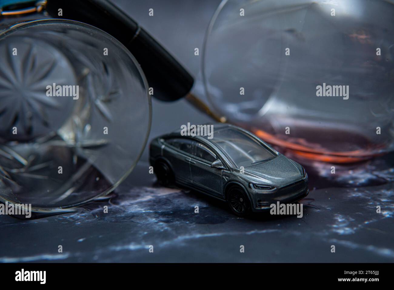 concept showing drunk driving. A toy car next to alcohol glasses ...