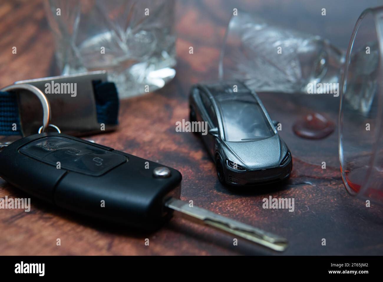 concept showing drunk driving. A toy car next to alcohol glasses ...