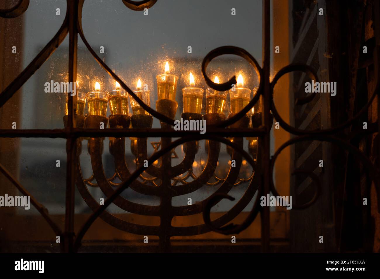 Burning Hanukkah candles cast a golden glow of firelight in the Old ...
