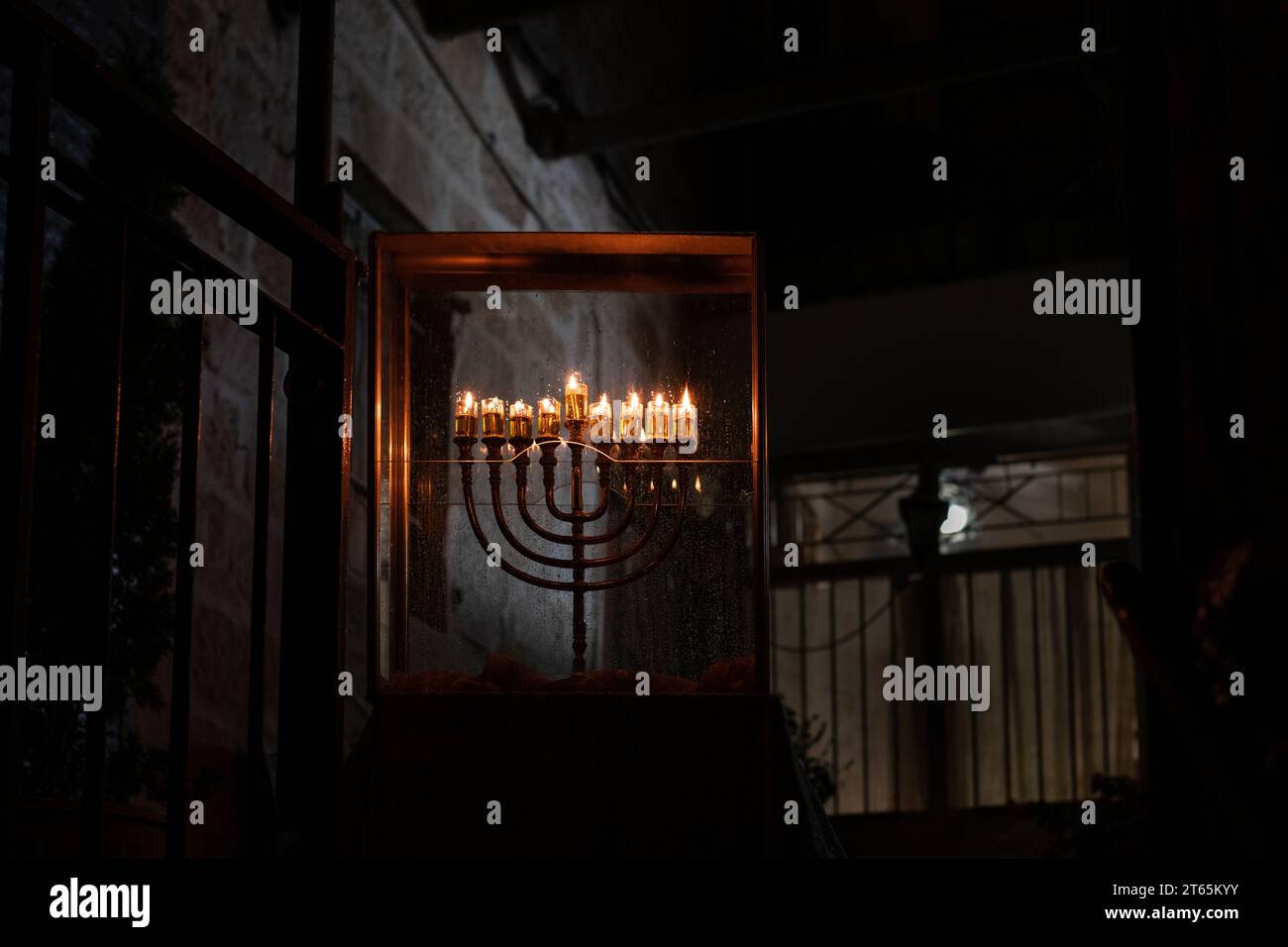 Burning Hanukkah candles cast a glow on the cobblestone streets of the ...