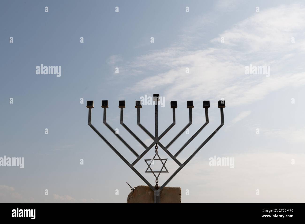 A large, metal, eight-branched Hanukkah menorah erected on a cement ...
