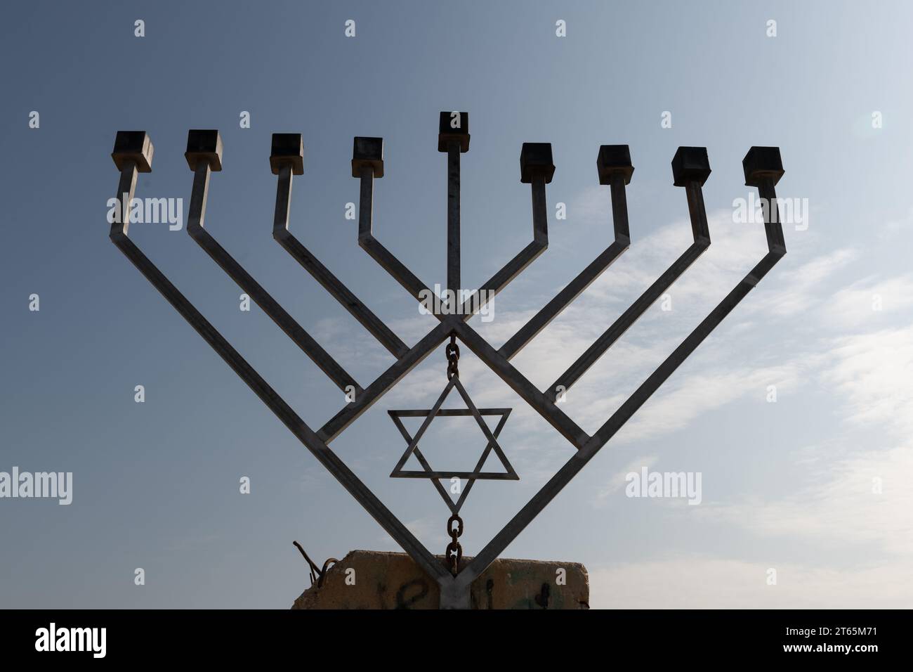 A large, metal, eight-branched Hanukkah menorah erected on a cement ...