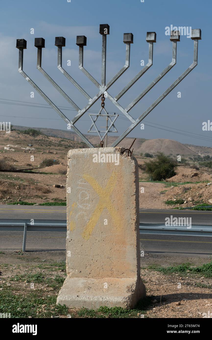 A large, metal, eight-branched Hanukkah menorah erected on a cement foundation and placed along ...