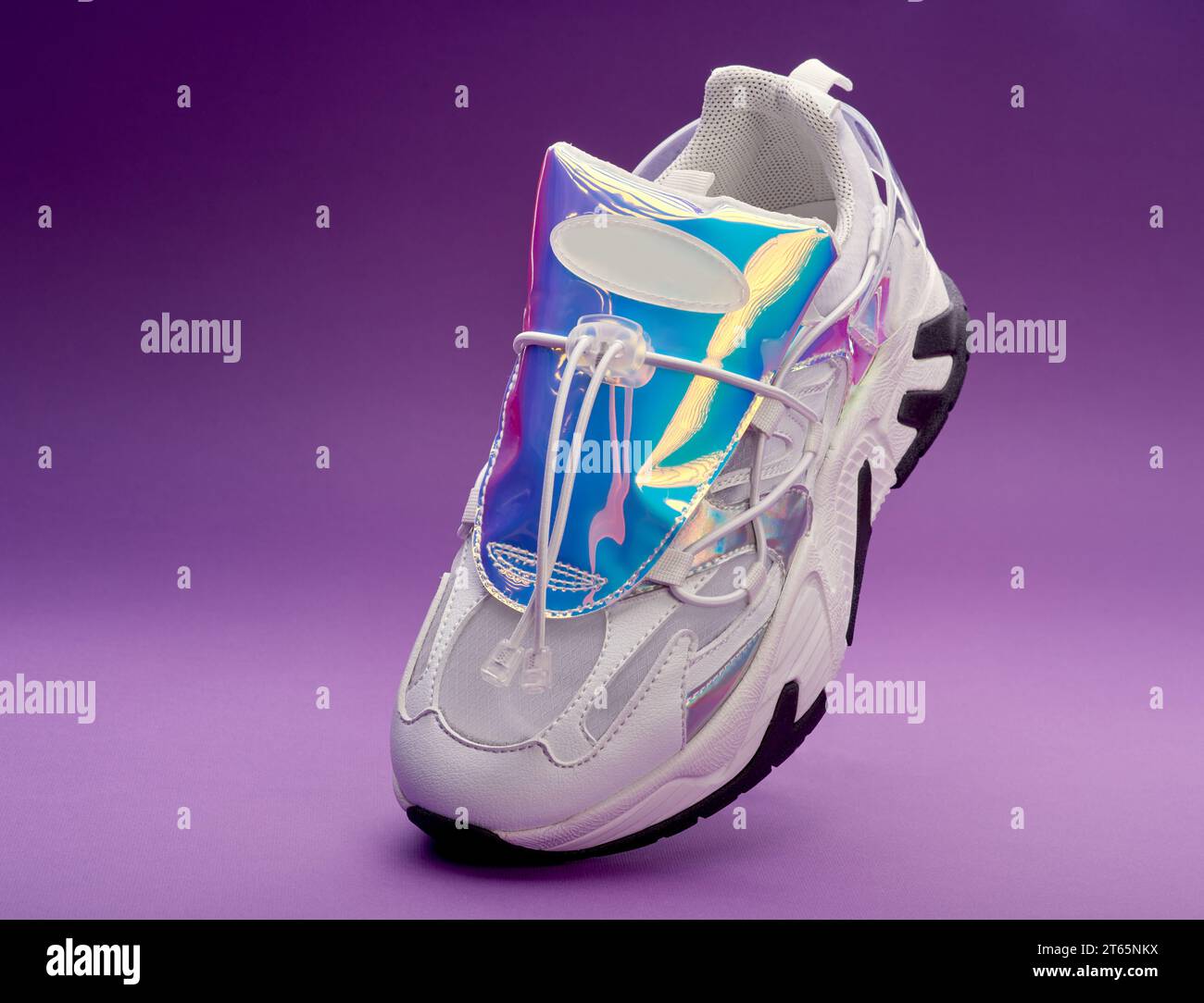 Close up view of female white trendy sneaker with holographic details ...