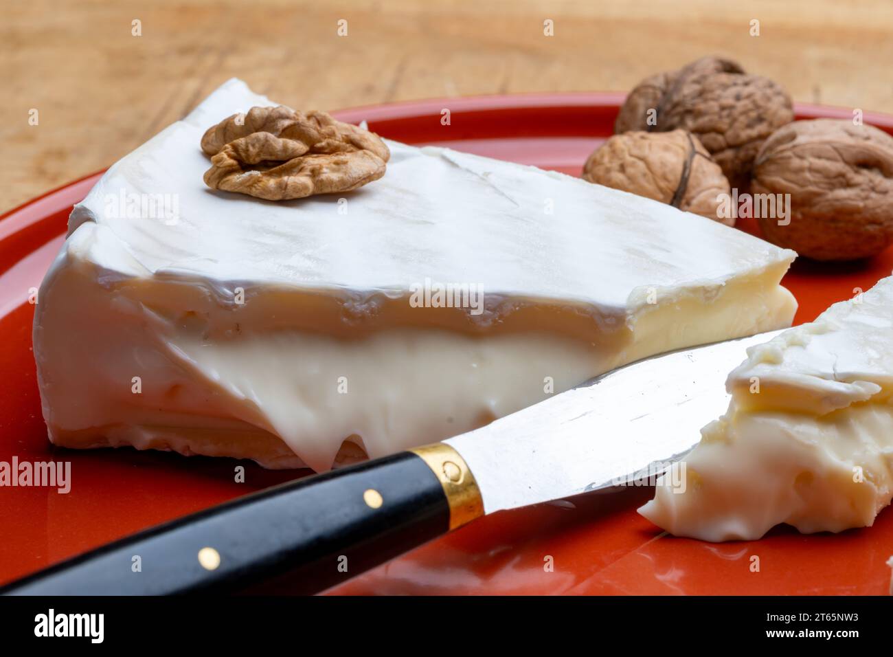 Piece of french soft-ripened white mold cow milk cheese brie produced ...
