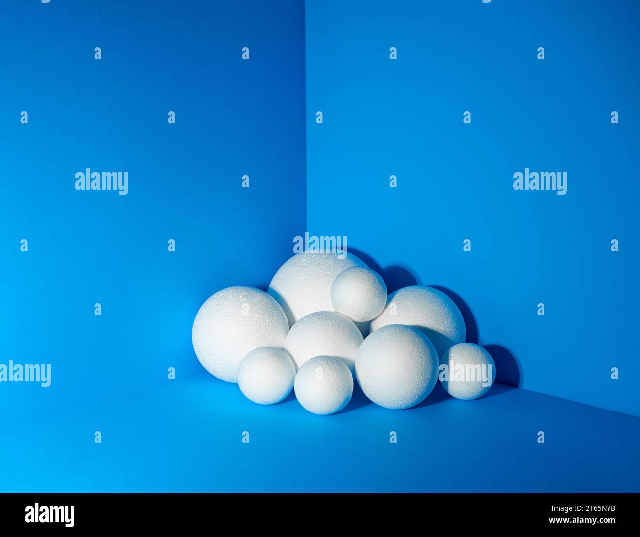 Multiple different sized white textured spheres in the corner of bright ...