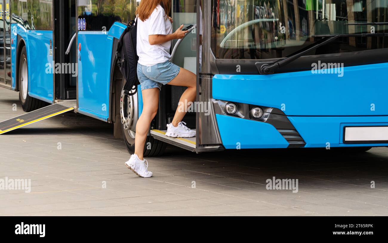 Female passenger boards the electric bus. Woman get on the trolleybus ...