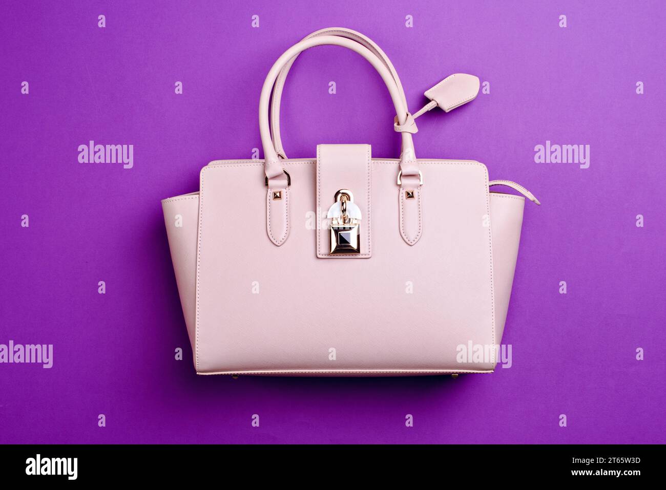 Fashionable pastel leather female bag with handles, tag, and metal ...