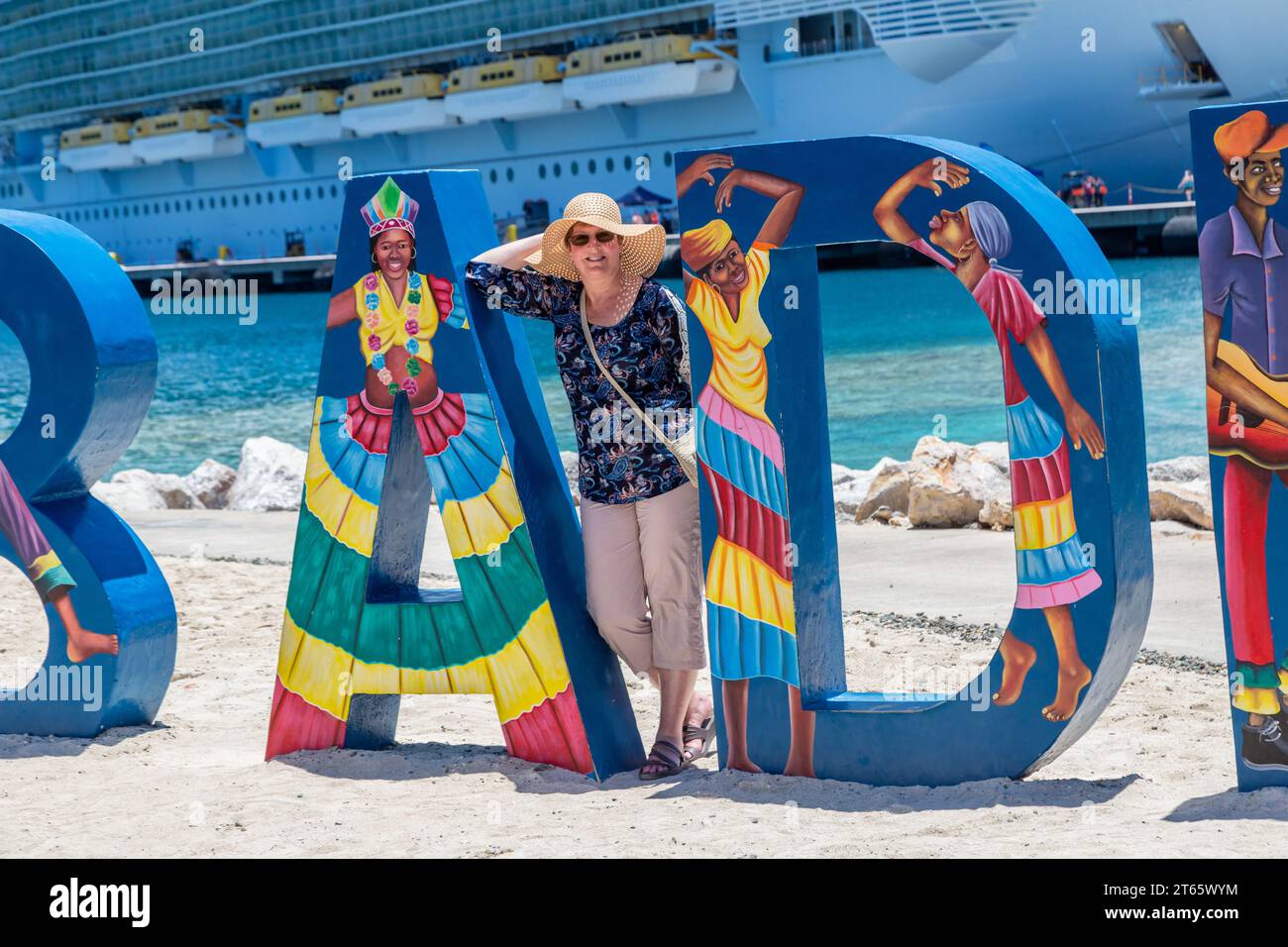 Woman leaning on large painted letters spelling out Labadee on the ...
