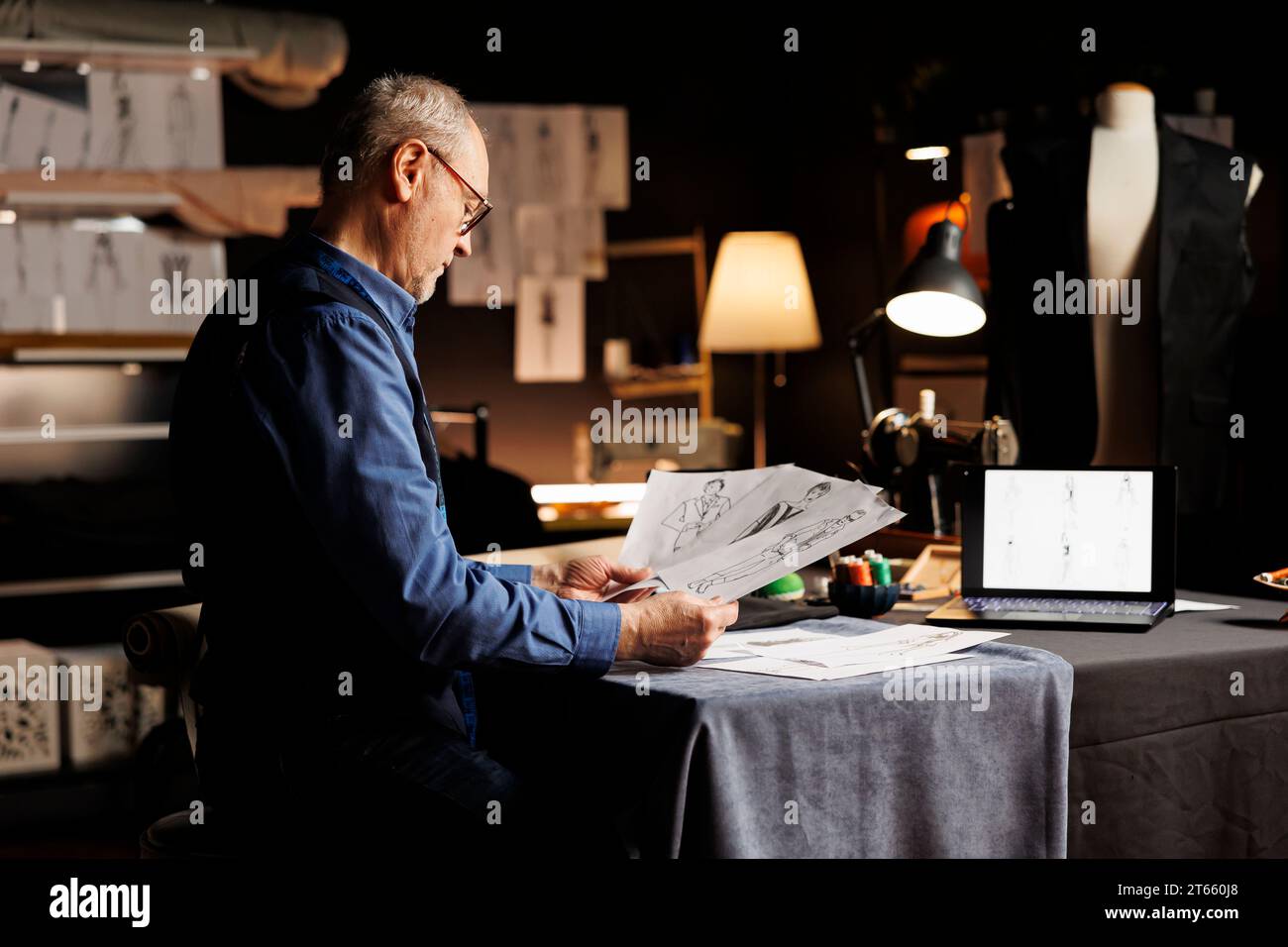 Dressmaker comparing handdrawn sketch designs, trying to pick perfect ...