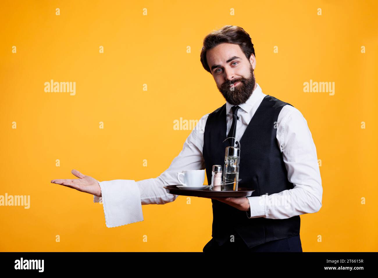 Skilled waiter shows direction to table at restaurant, serving people ...