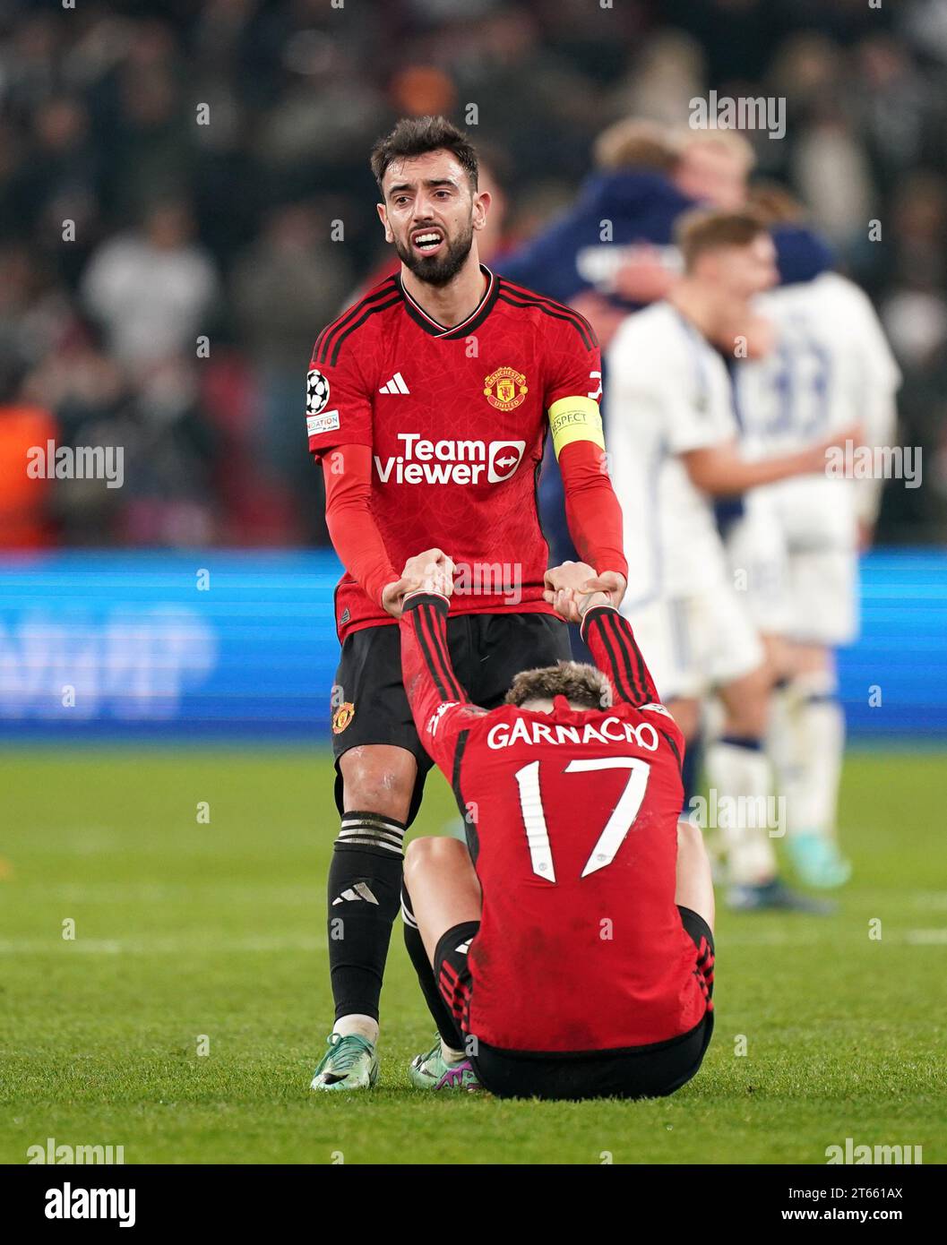 Manchester United's Bruno Fernandes (left) helps up team-mate Alejandro ...