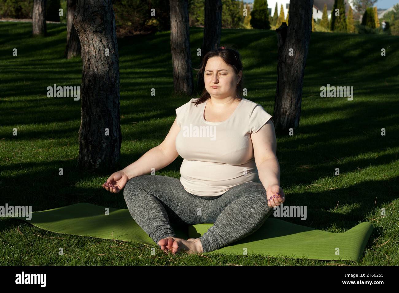 Portrait of overweight Caucasian middle-aged woman practicing yoga in ...