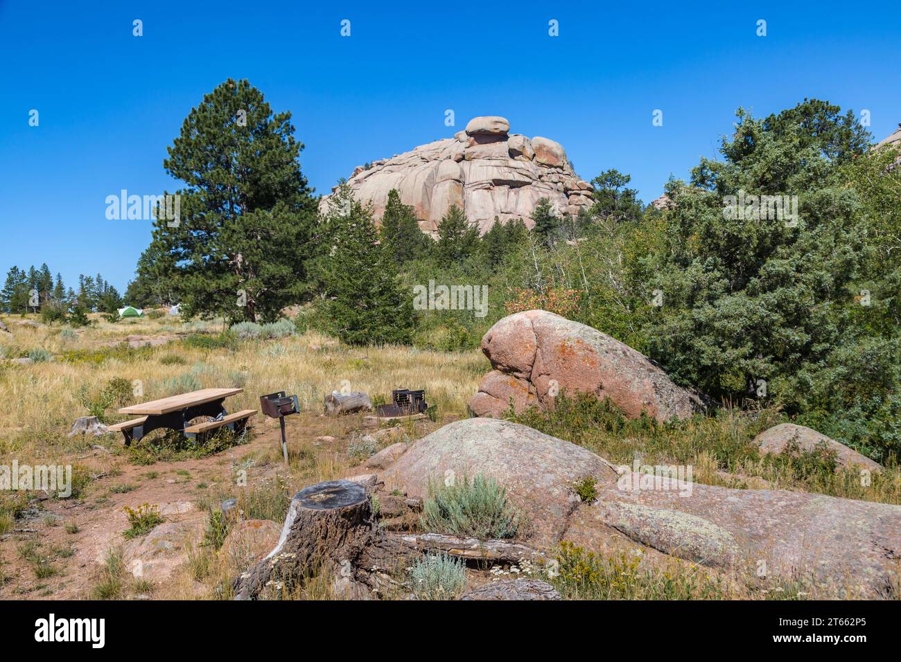 Granite rock outcropping behind a camp site with a picnic table, fire ...