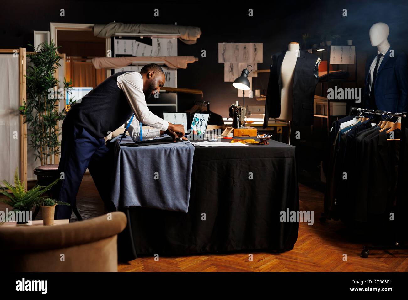 Smiling tailor showing precise craftmanship in professional atelier ...