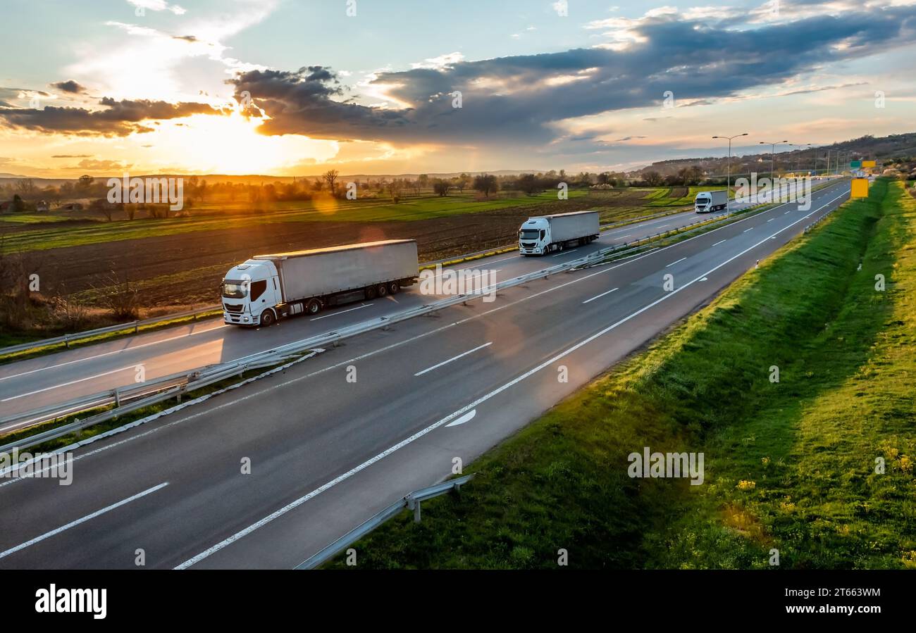 Highway transportation scene with Convoy of white transportation trucks ...