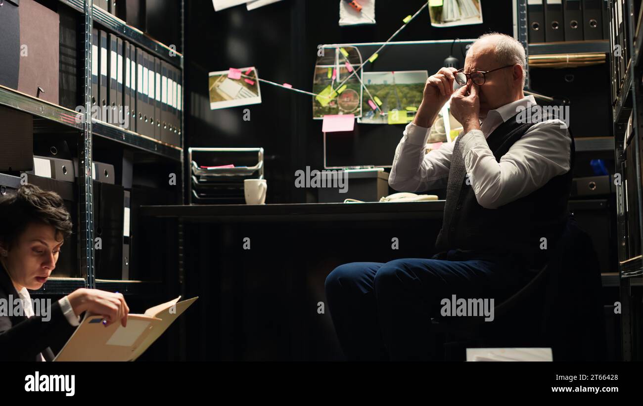 Senior agent working with criminologist, inspector feeling stressed ...