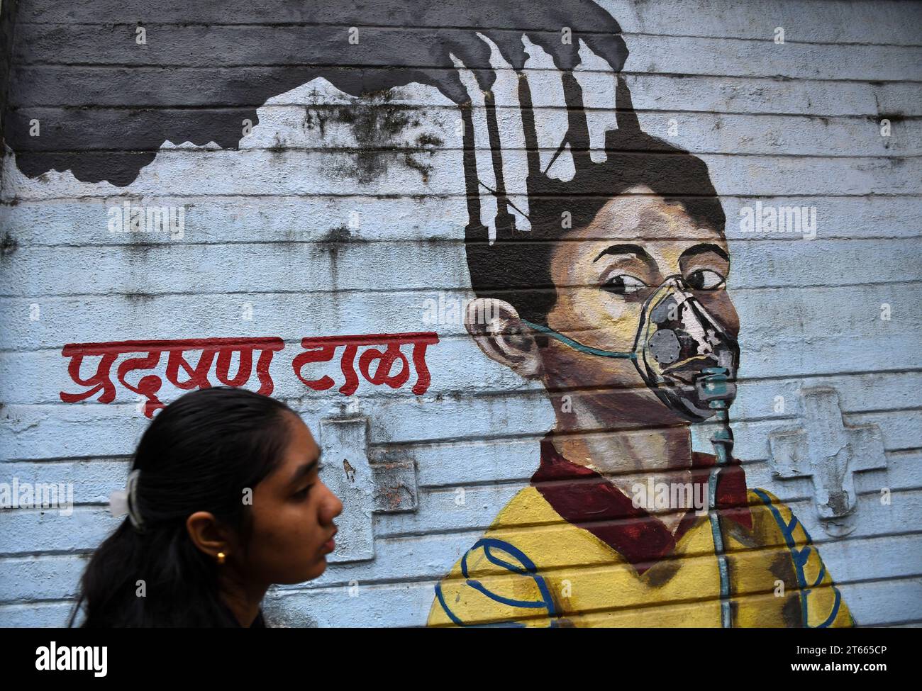 A woman walks past a mural painted on the wall to create awareness ...