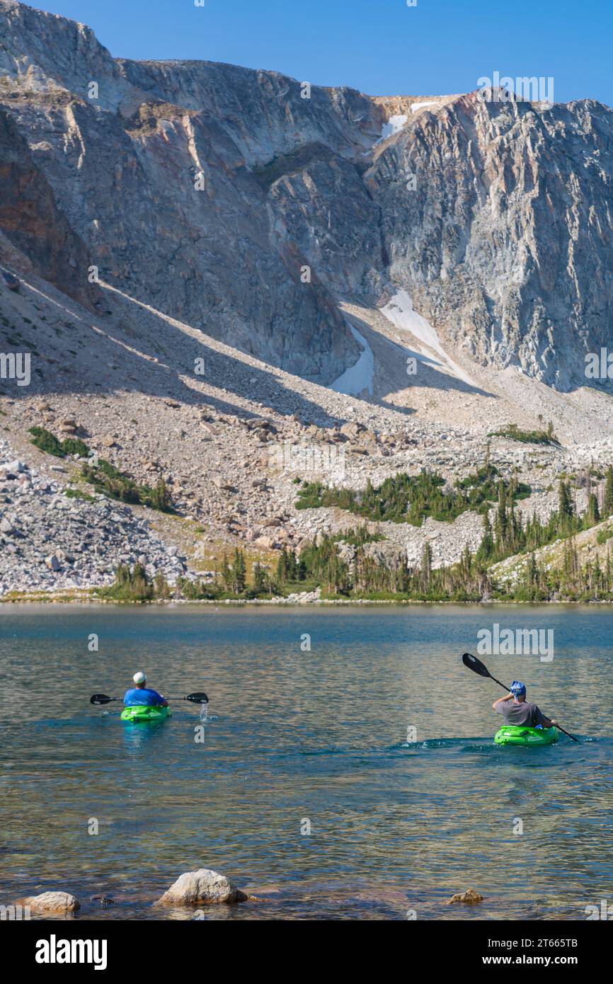 Two young men prepare for kayaking along the rock shoreline of Lake ...