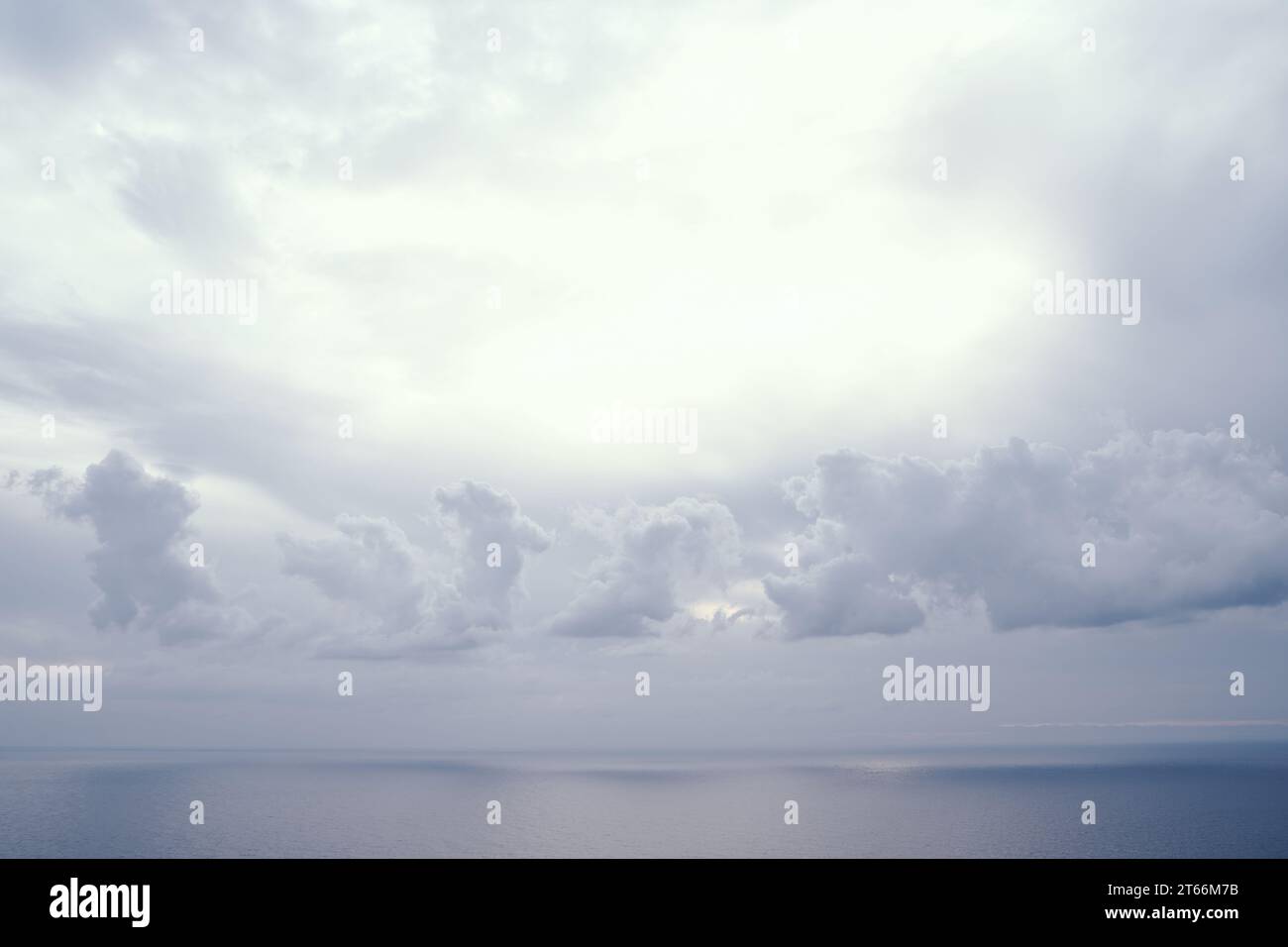 Sunshine shines through storm clouds over the blue sea Stock Photo - Alamy