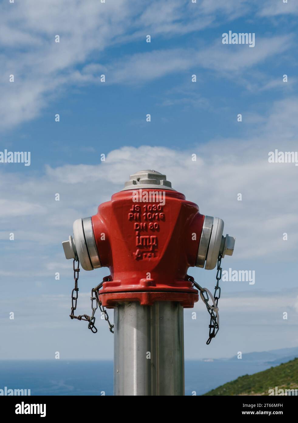 Ground red fire hydrant against a cloudy sky Stock Photo - Alamy