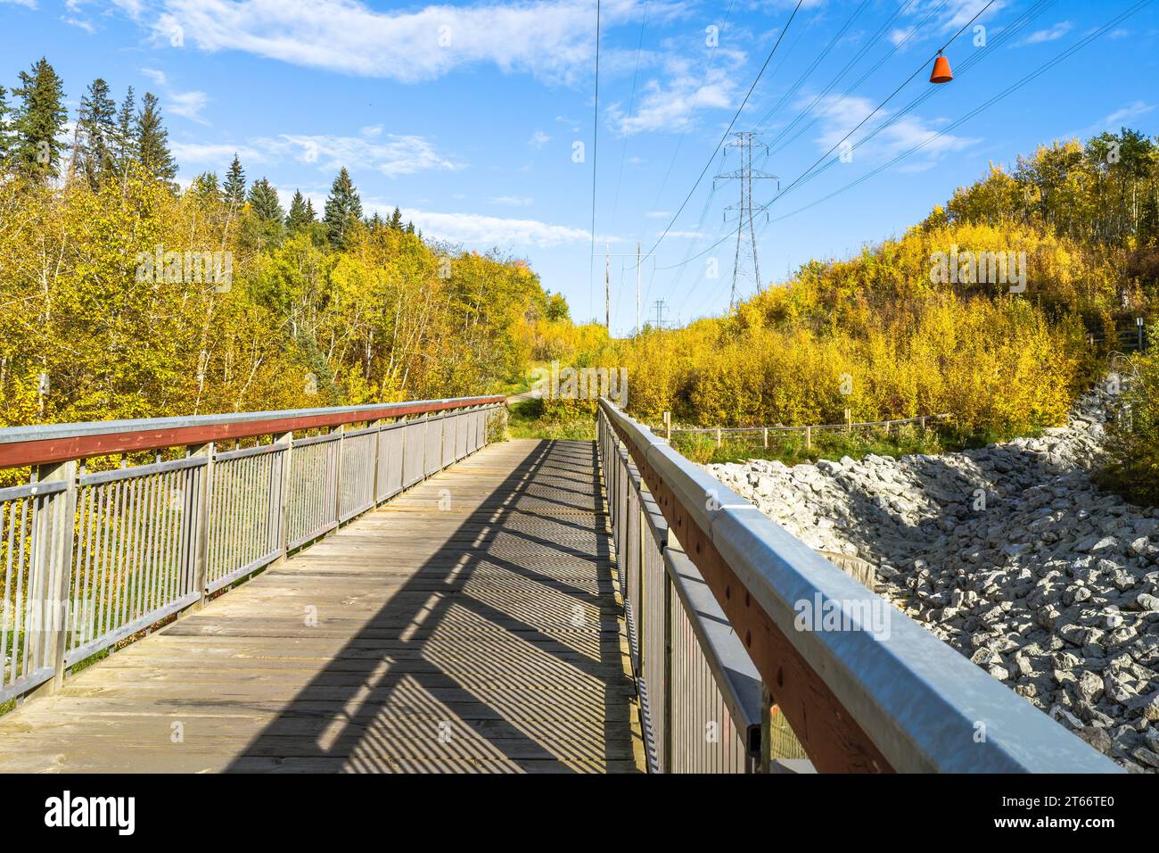 White Mud Creek footbridge under power line in fall season with yellow ...