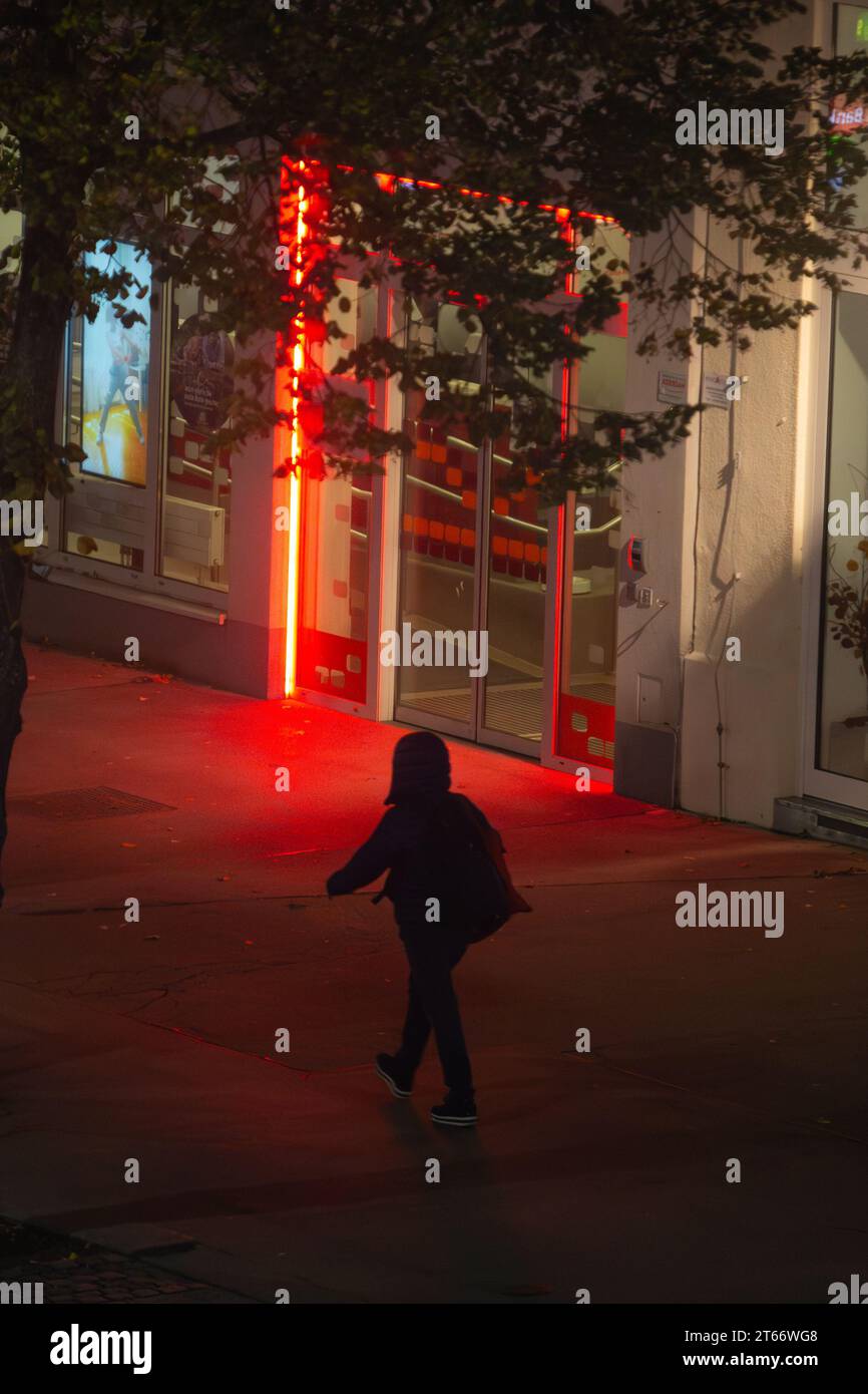 A man in winter clothes walks on the sidewalk against the background of ...