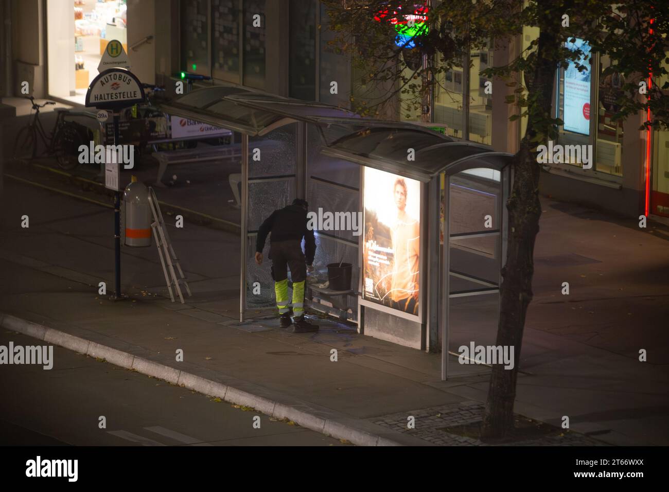 A janitor in black clothes with yellow boots equipped with a bucket is ...