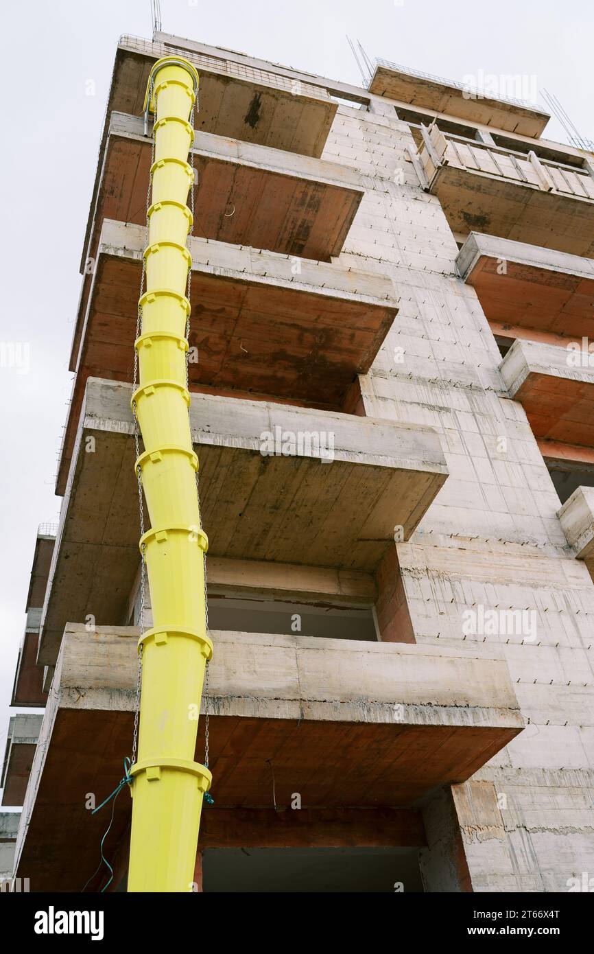 Long yellow pipe stretches up along the balconies of an apartment ...