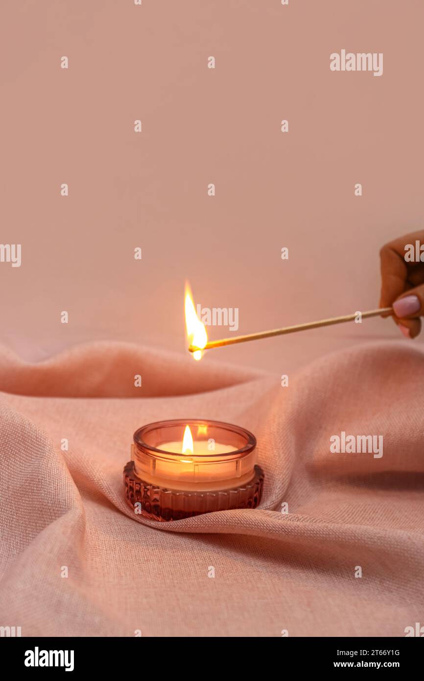 Hand of woman with match lighting candle Stock Photo - Alamy