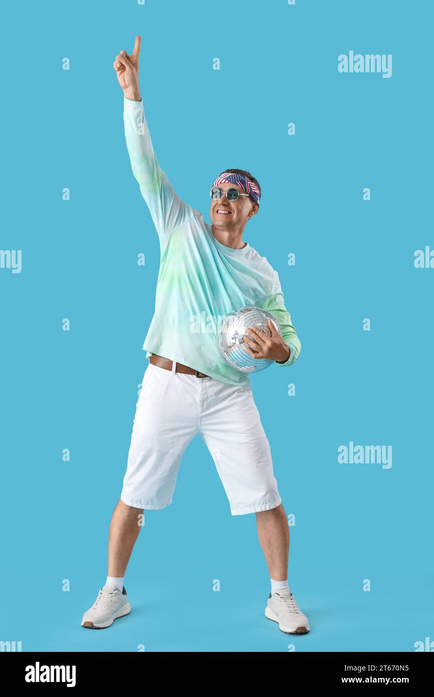 Cool mature man with disco ball dancing on blue background Stock Photo ...