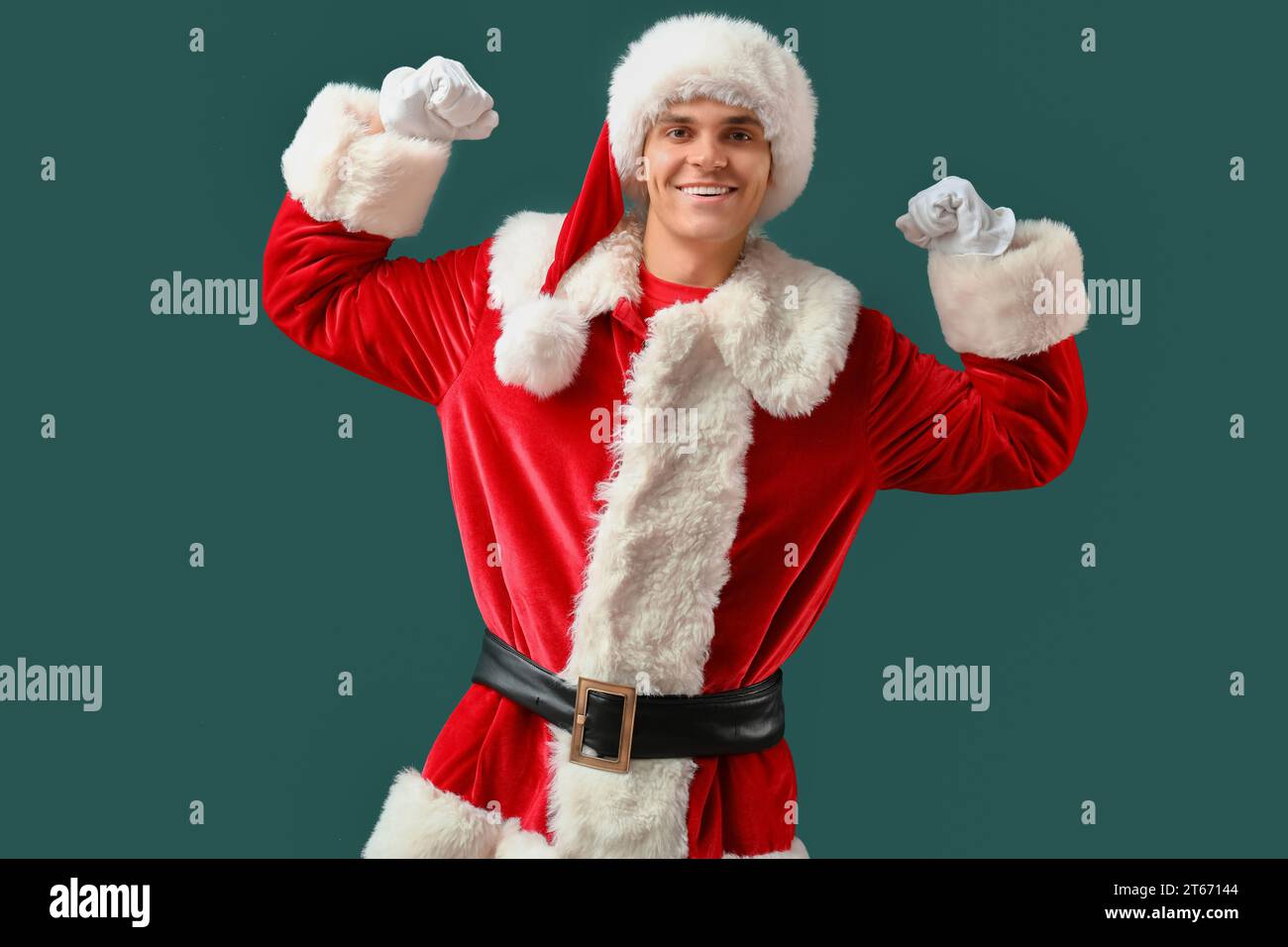 Santa Claus showing muscles on dark green background Stock Photo - Alamy